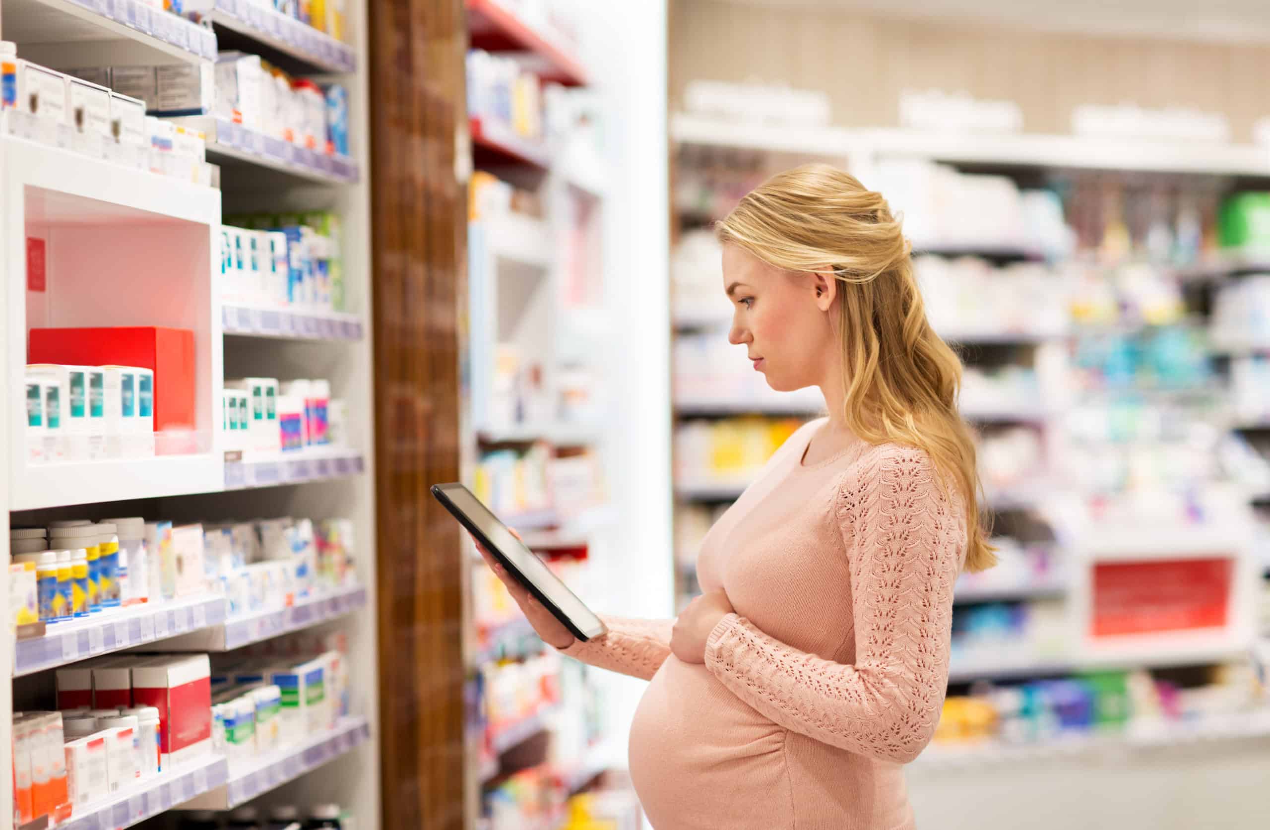 pregnant woman with tablet pc at pharmacy - Full Time Baby